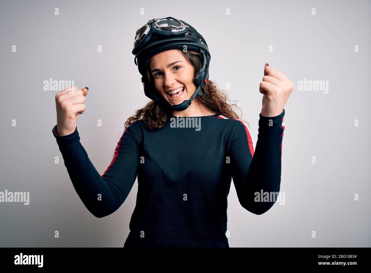 Beautiful motorcyclist woman with curly hair wearing moto helmet over ...