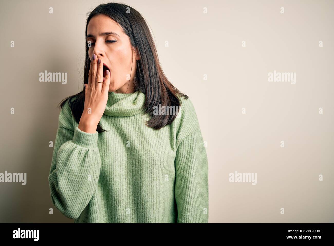 Young brunette woman with blue eyes wearing turtleneck sweater over ...