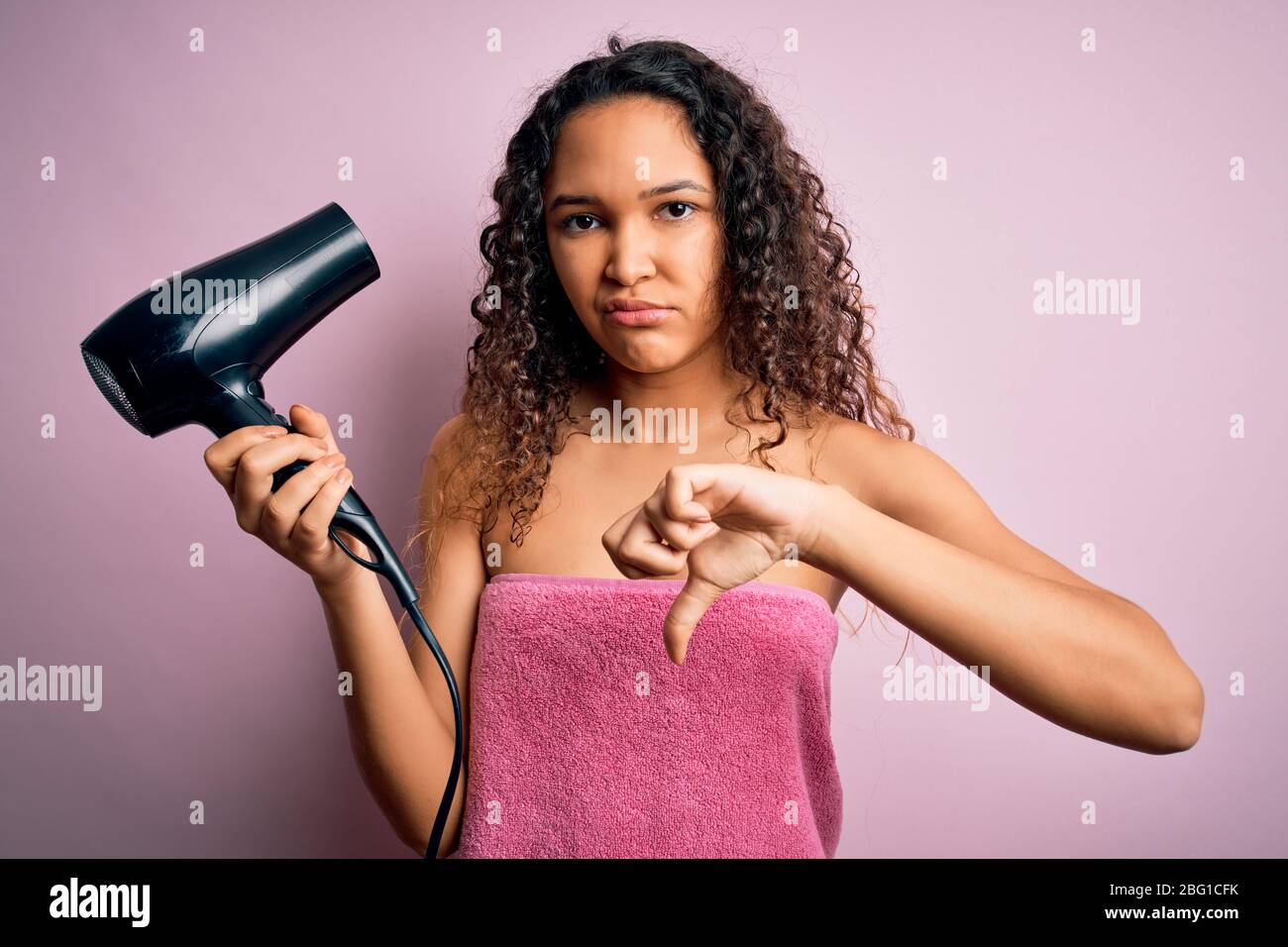 Beautiful woman with curly hair wearing shower towel after bath using ...