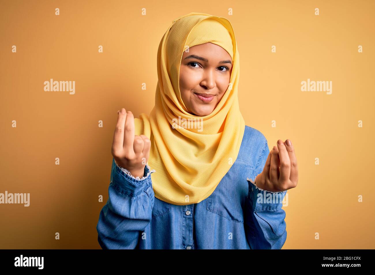 Young beautiful woman with curly hair wearing arab traditional hijab ...