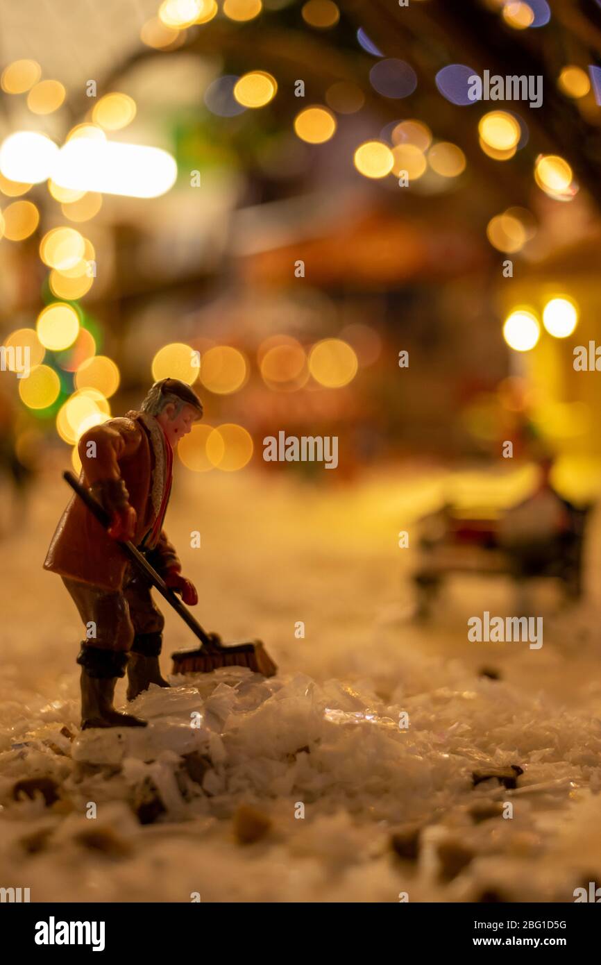 A Christmas scene of a man shoveling snow made from models at a ...