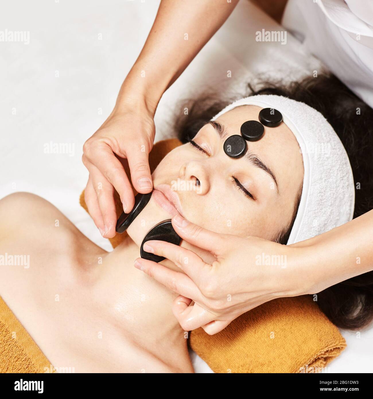 facial stone massage. Hot face masseur. Girl at salon with doctor hands ...