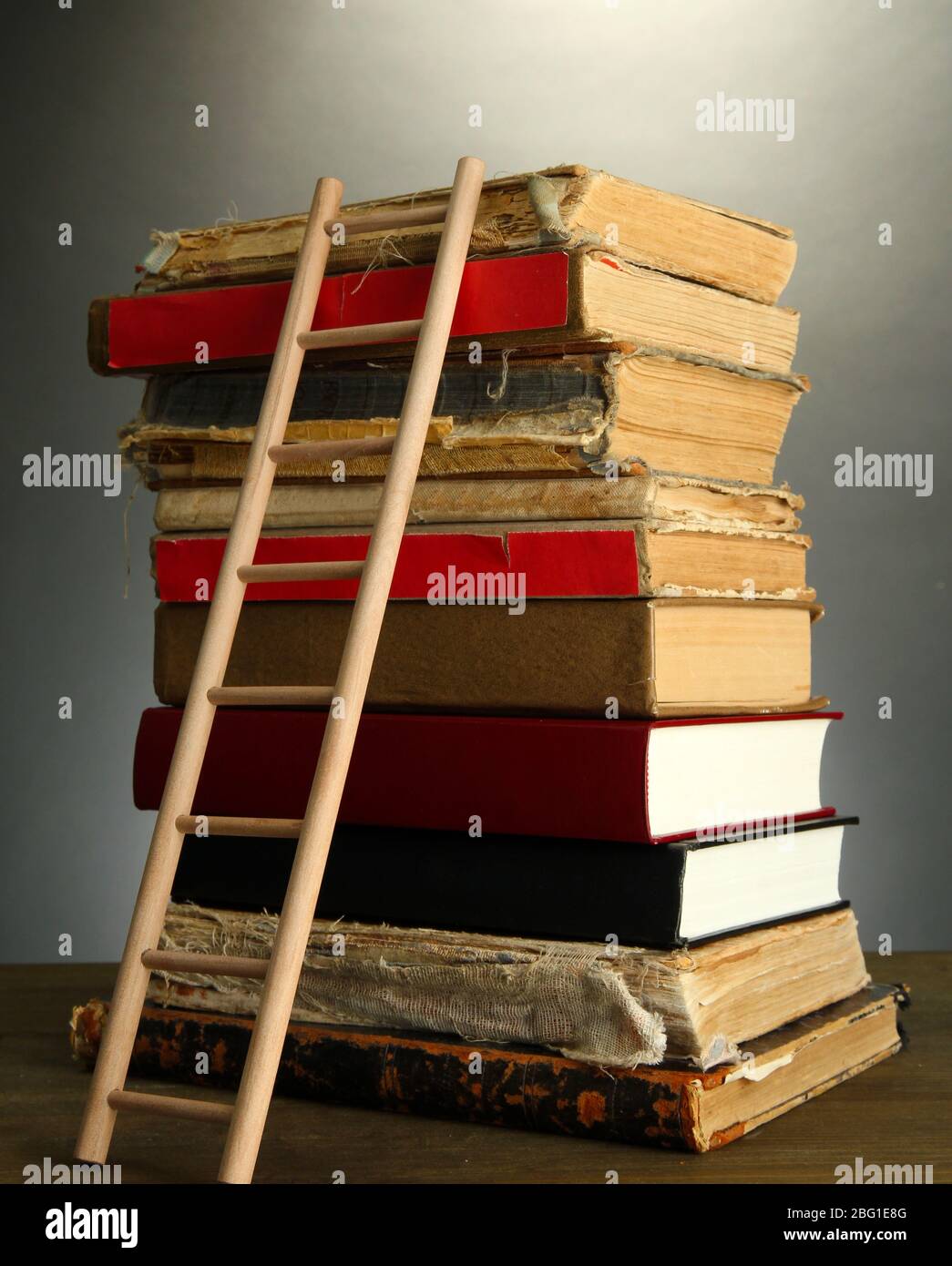 Old books and wooden ladder, on grey background Stock Photo - Alamy