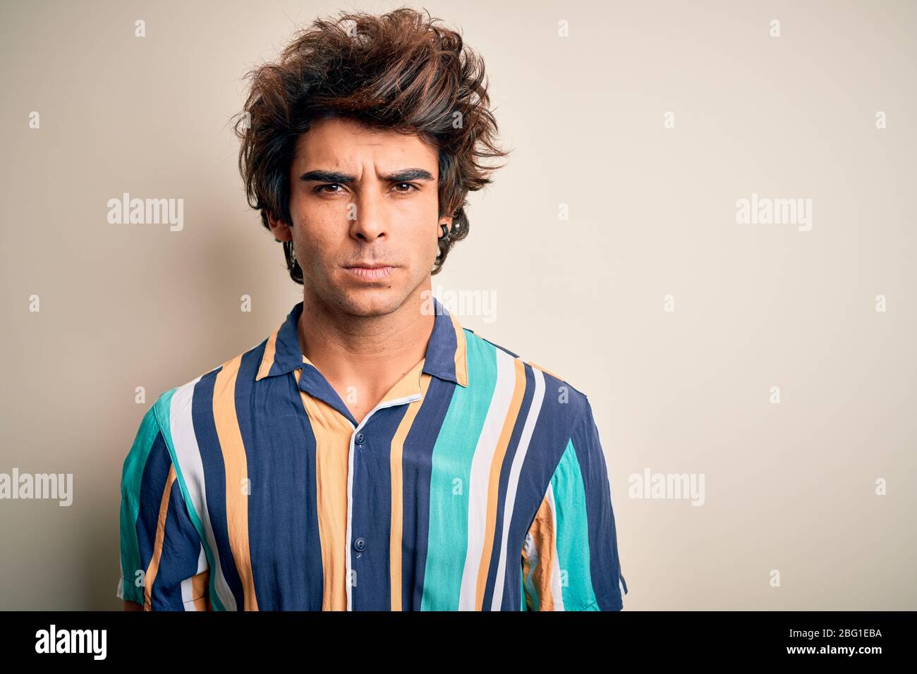 Young man on vacation wearing summer colorful shirt standing over ...