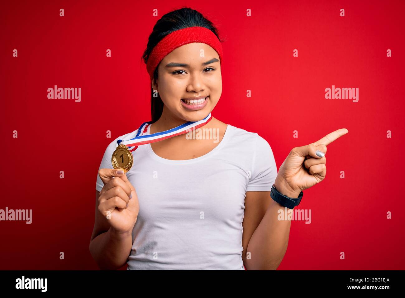 Young asian champion girl winning medal standing over isolated red ...