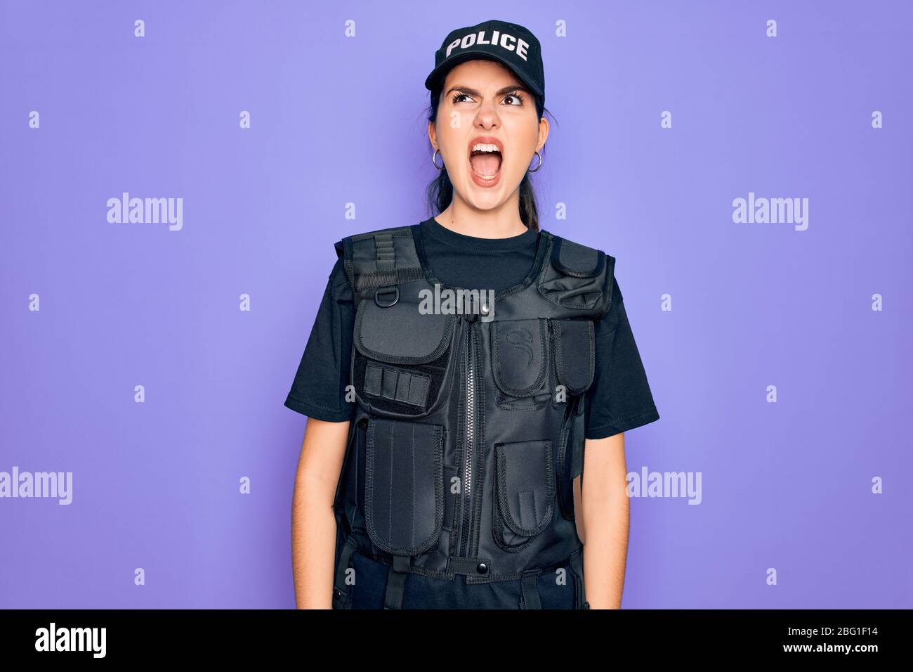 Young police woman wearing security bulletproof vest uniform over ...