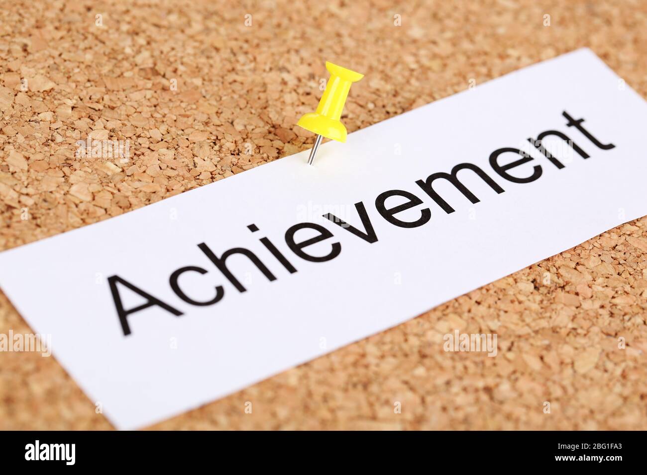 Push pin on paper with word achievement on cork board Stock Photo - Alamy