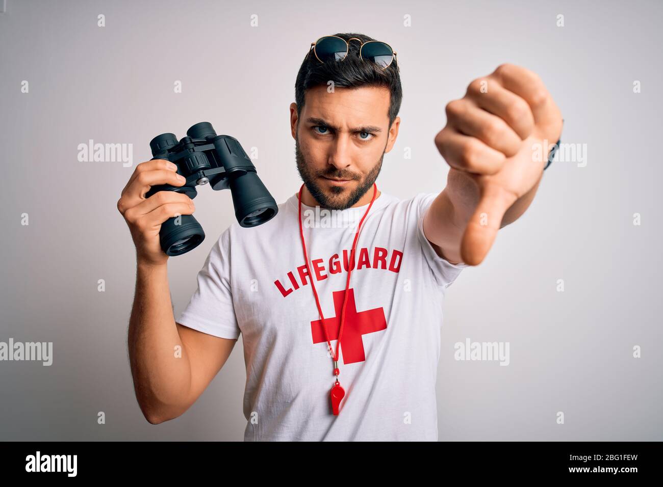 Young lifeguard man with beard wearing t-shirt with red cross and ...