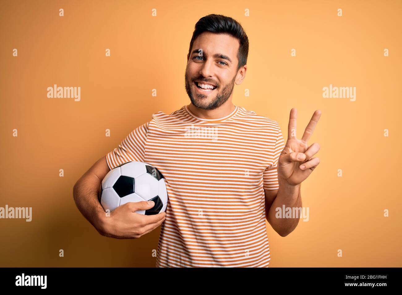 Handsome player man with beard playing soccer holding footballl ball ...
