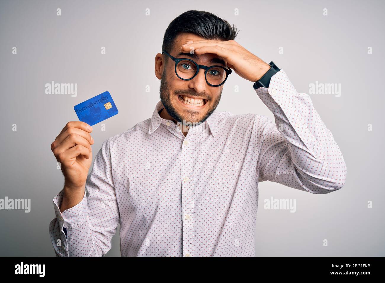 Young business man holding credit card over isolated background ...