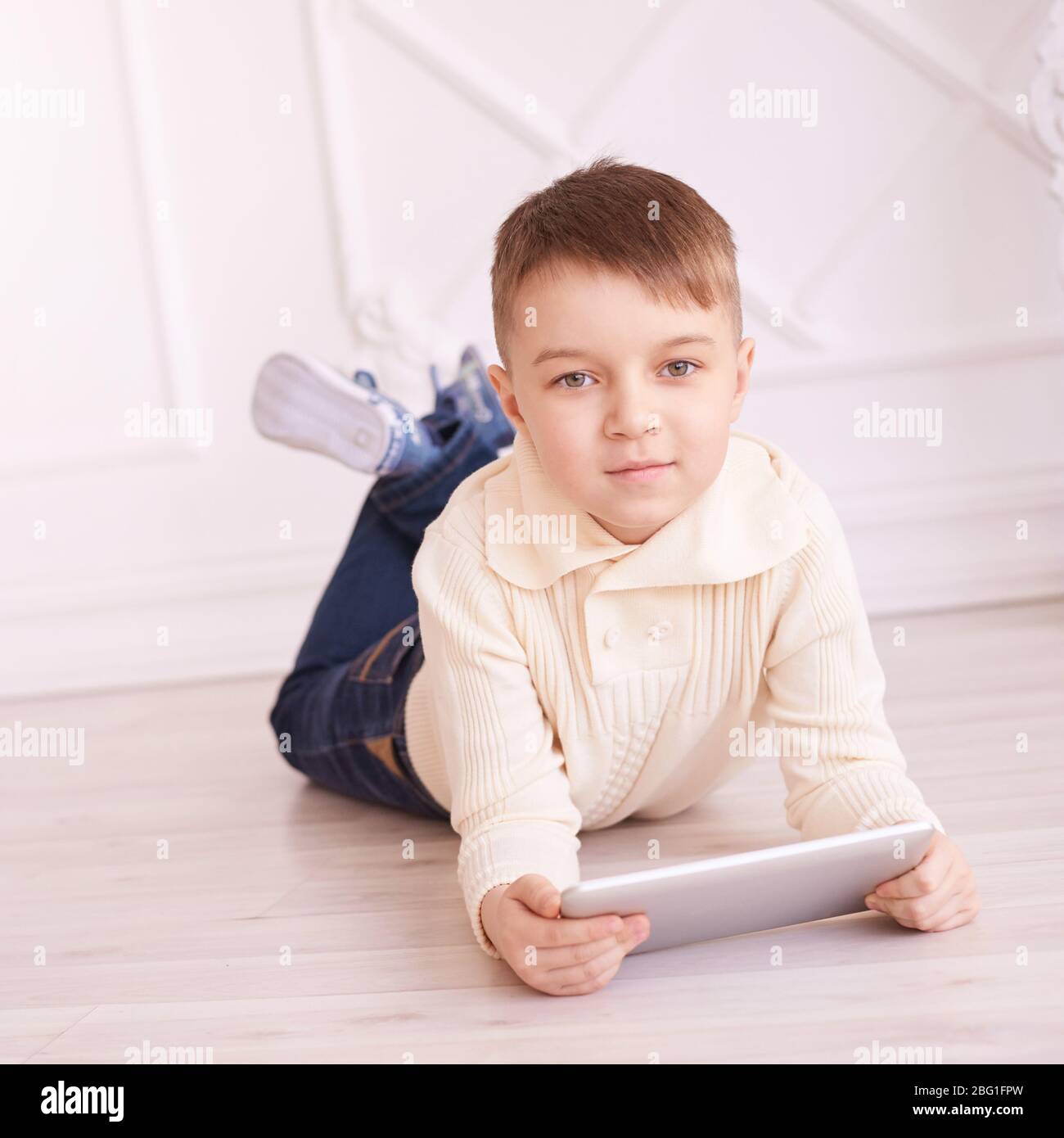 Cute boy. Computer tablet. Training. light interior Stock Photo - Alamy