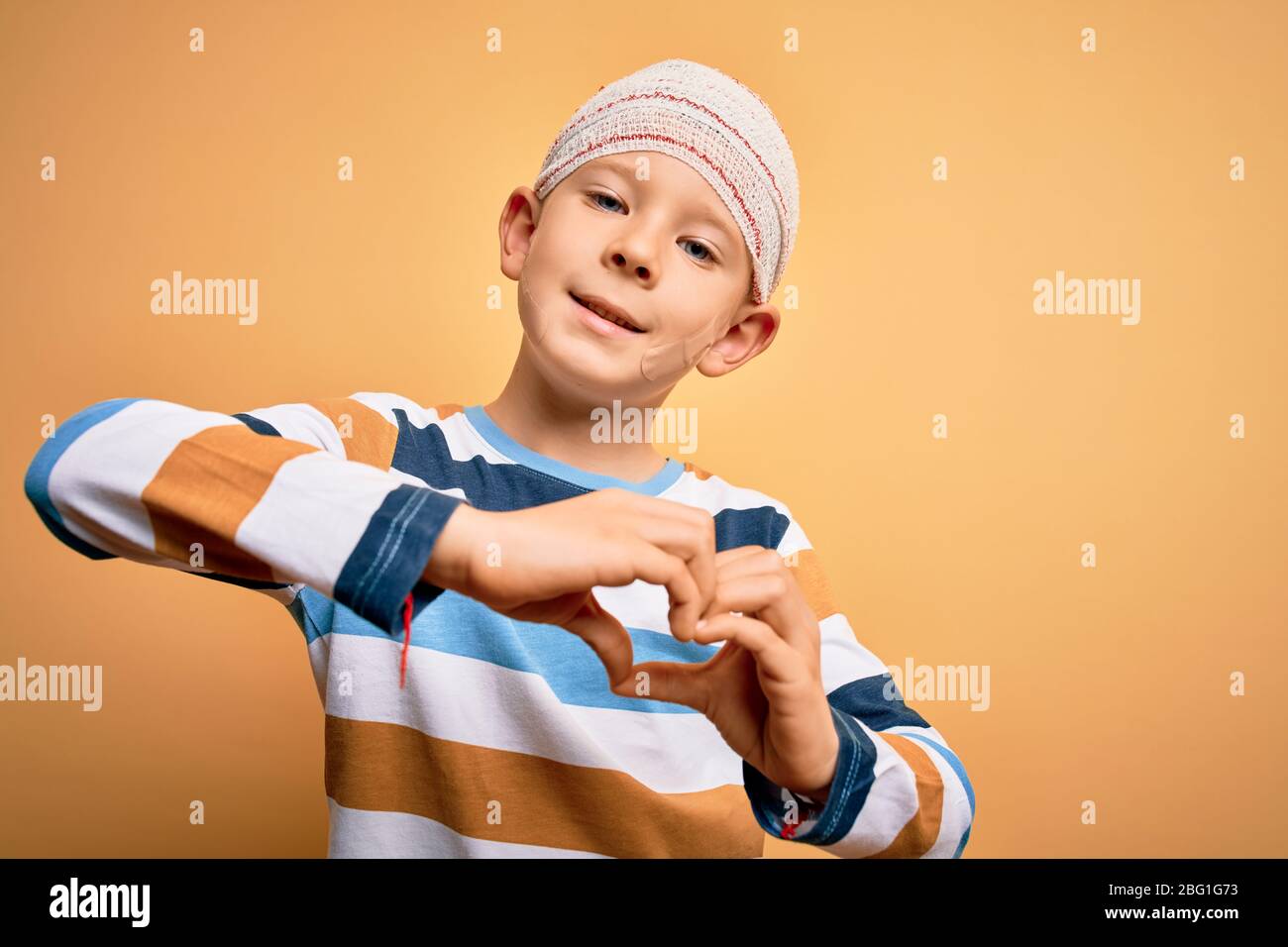 Young little caucasian kid injured wearing medical bandage on head over ...