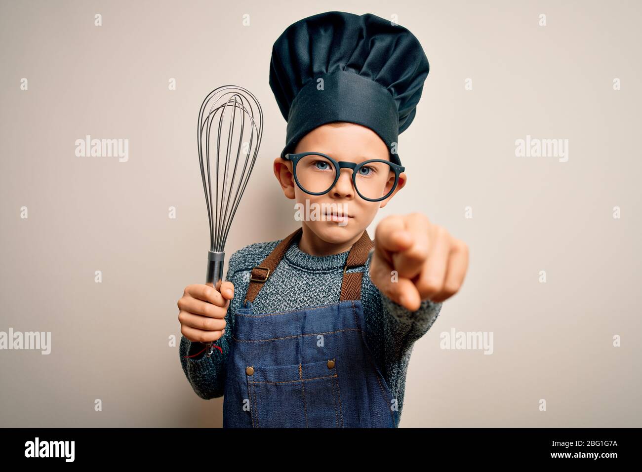 Young little caucasian cook kid wearing chef uniform and hat using ...