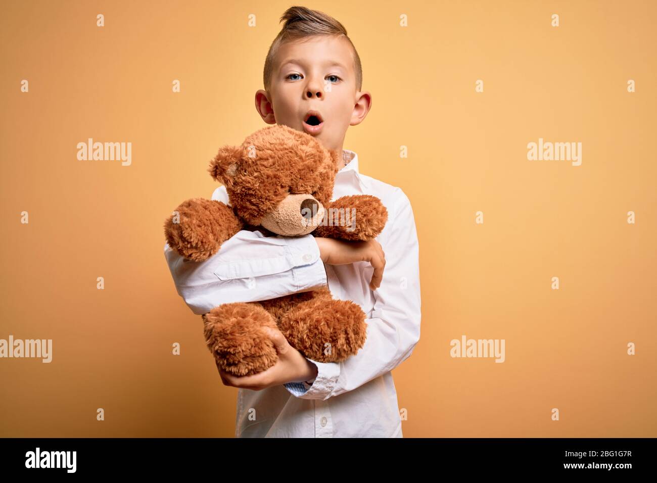 Young little caucasian kid hugging teddy bear stuffed animal over ...