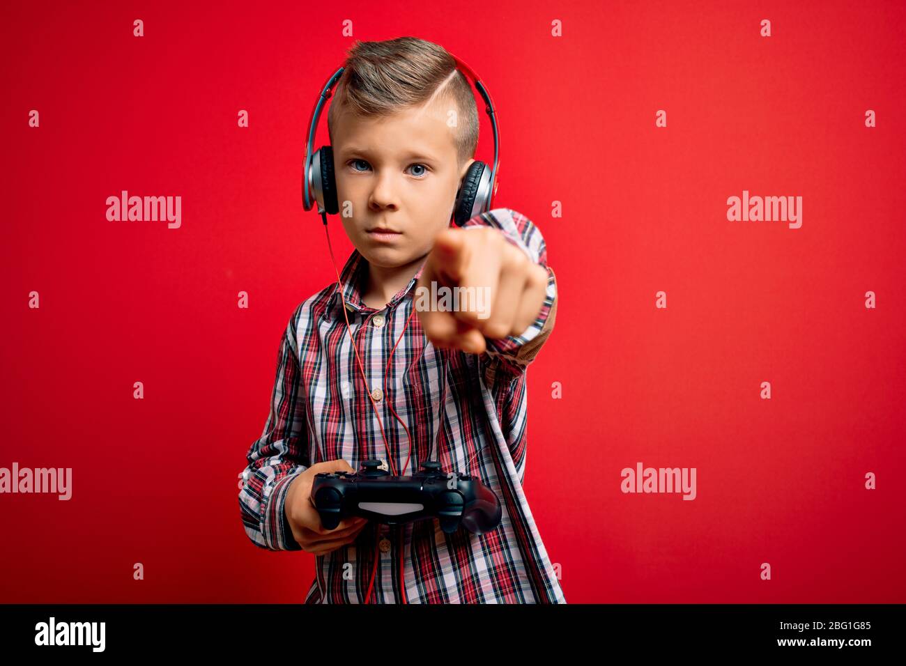 Young little caucasian gamer kid playing video games using gamepad ...