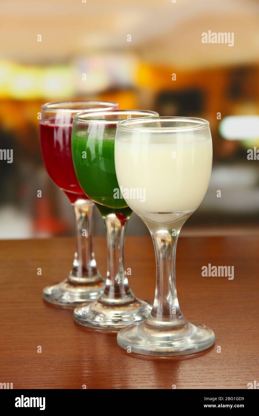 Tasty color liquors, on bright background Stock Photo - Alamy