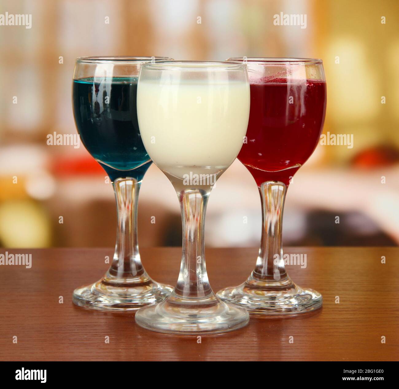Tasty color liquors, on bright background Stock Photo - Alamy