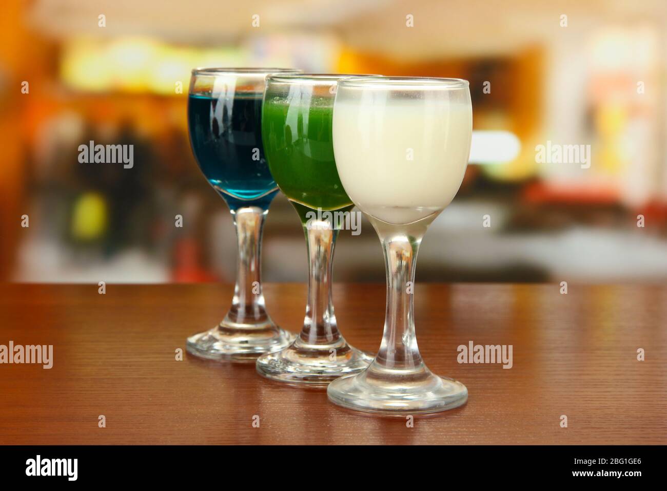 Tasty color liquors, on bright background Stock Photo - Alamy