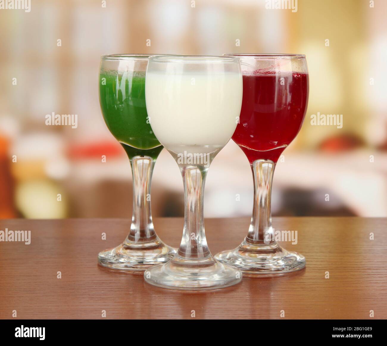 Tasty color liquors, on bright background Stock Photo - Alamy