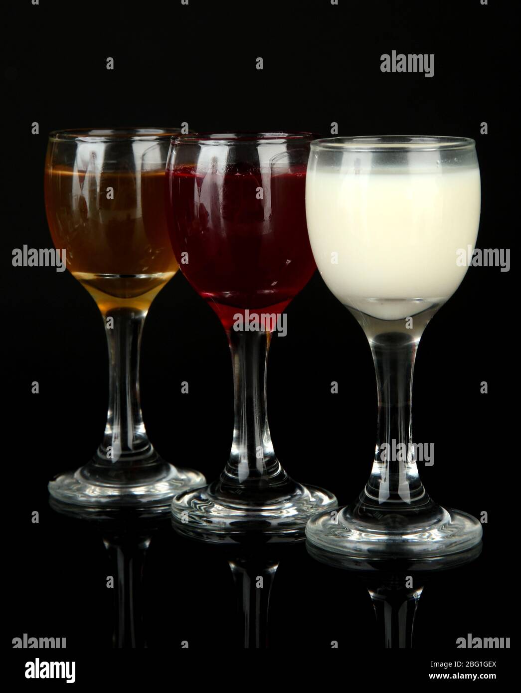 Tasty color liquors, isolated on black Stock Photo - Alamy