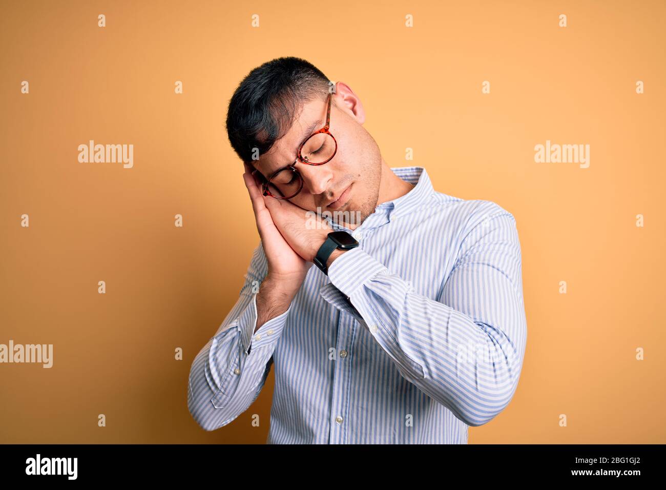 Young handsome hispanic business man wearing nerd glasses over yellow ...