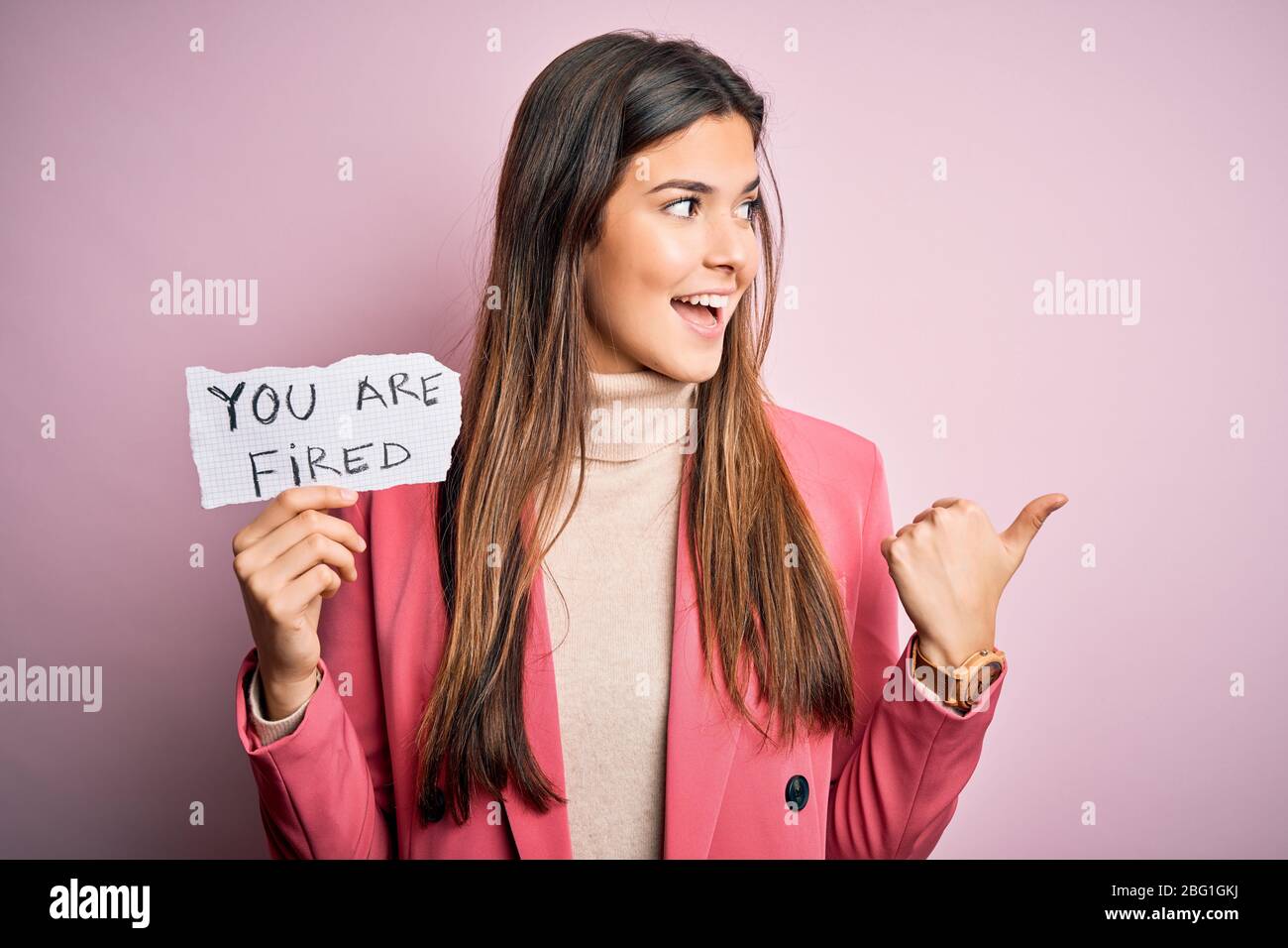 Young beautiful girl holding paper with you are fired message over ...