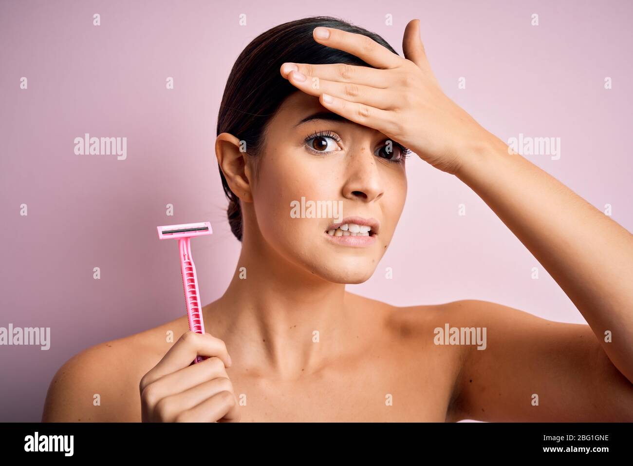 Young beautiful girl using shaver for depilation standing over isolated ...