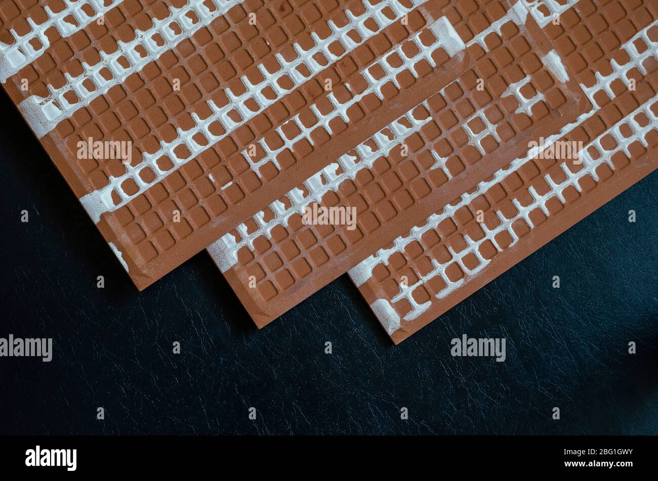 Ceramic tile back side. Three ceramic tiles on a black background. The ...