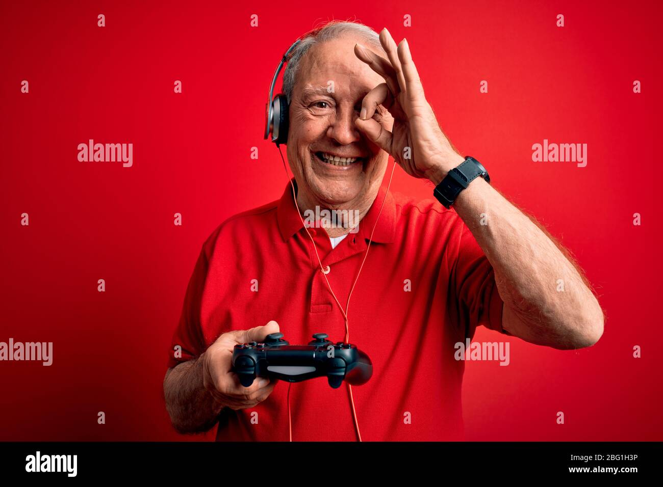 Senior grey haired gamer man playing video games using gamepad joystick ...