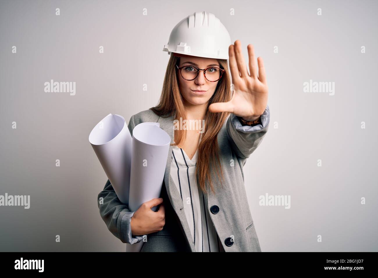 Young beautiful redhead architect woman wearing glasses and safety ... Young beautiful redhead architect woman wearing glasses and safety ...
