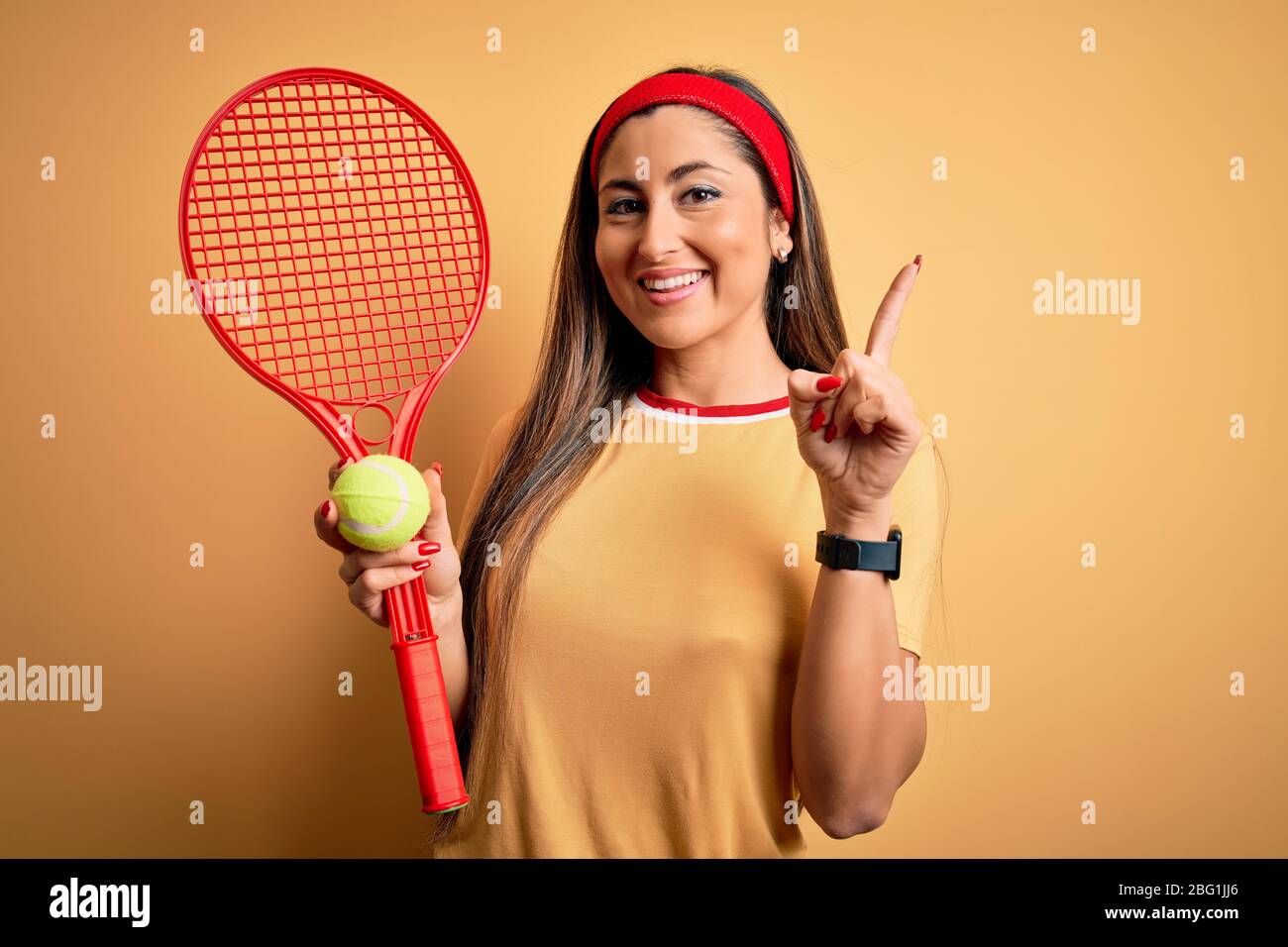 Beautiful brunette sportswoman playing tennis using racket and ball ...