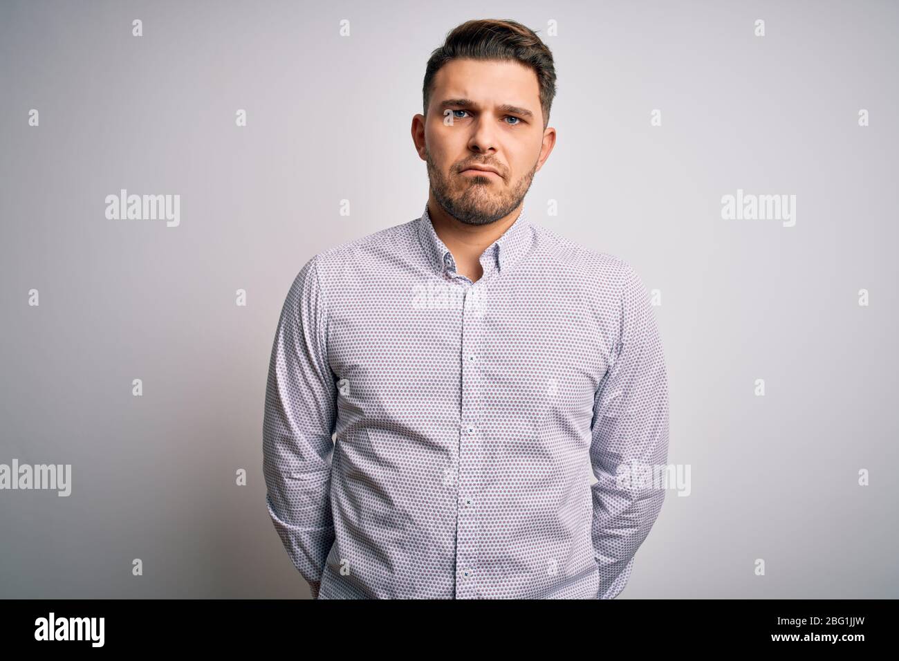 Young business man with blue eyes standing over isolated background ...