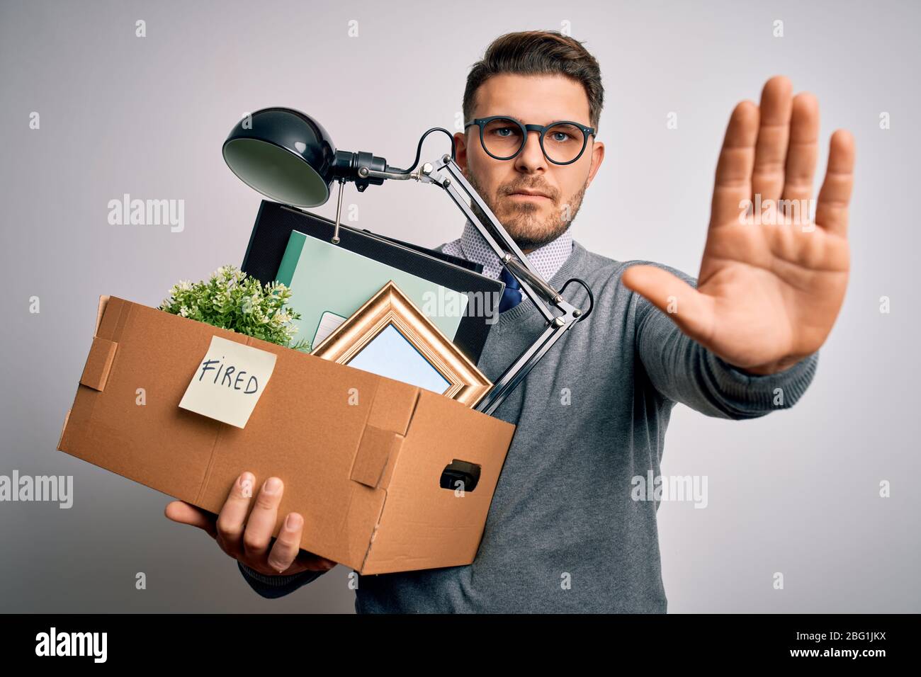 Young business man with blue eyes holding box from the office beeing ...