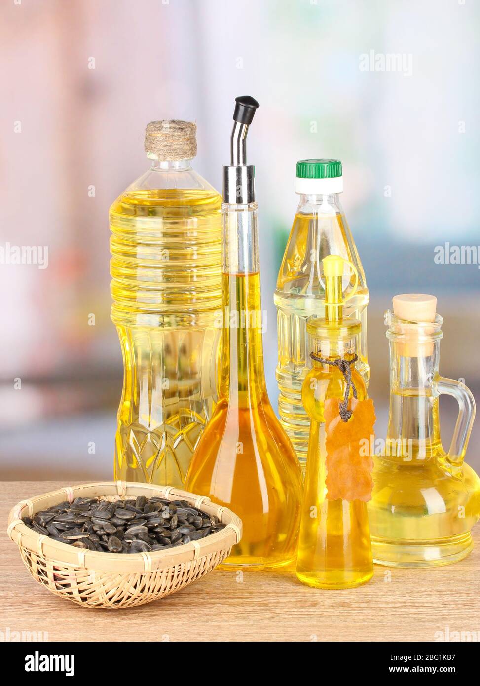 Different types of oil with sunflower seeds on table in kitchen Stock ...