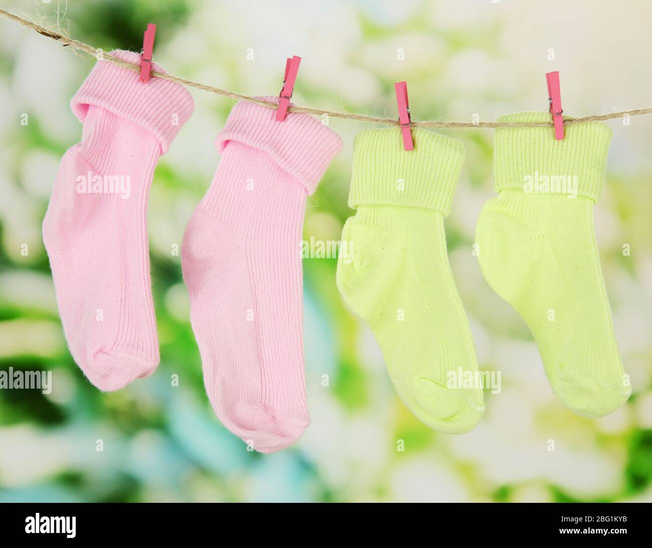 Colorful socks hanging on clothesline, on bright background Stock Photo ...