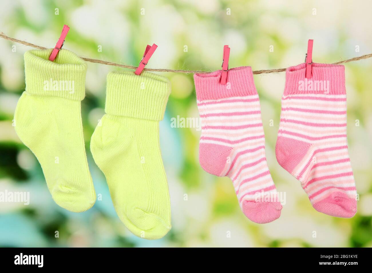 Colorful socks hanging on clothesline, on bright background Stock Photo ...