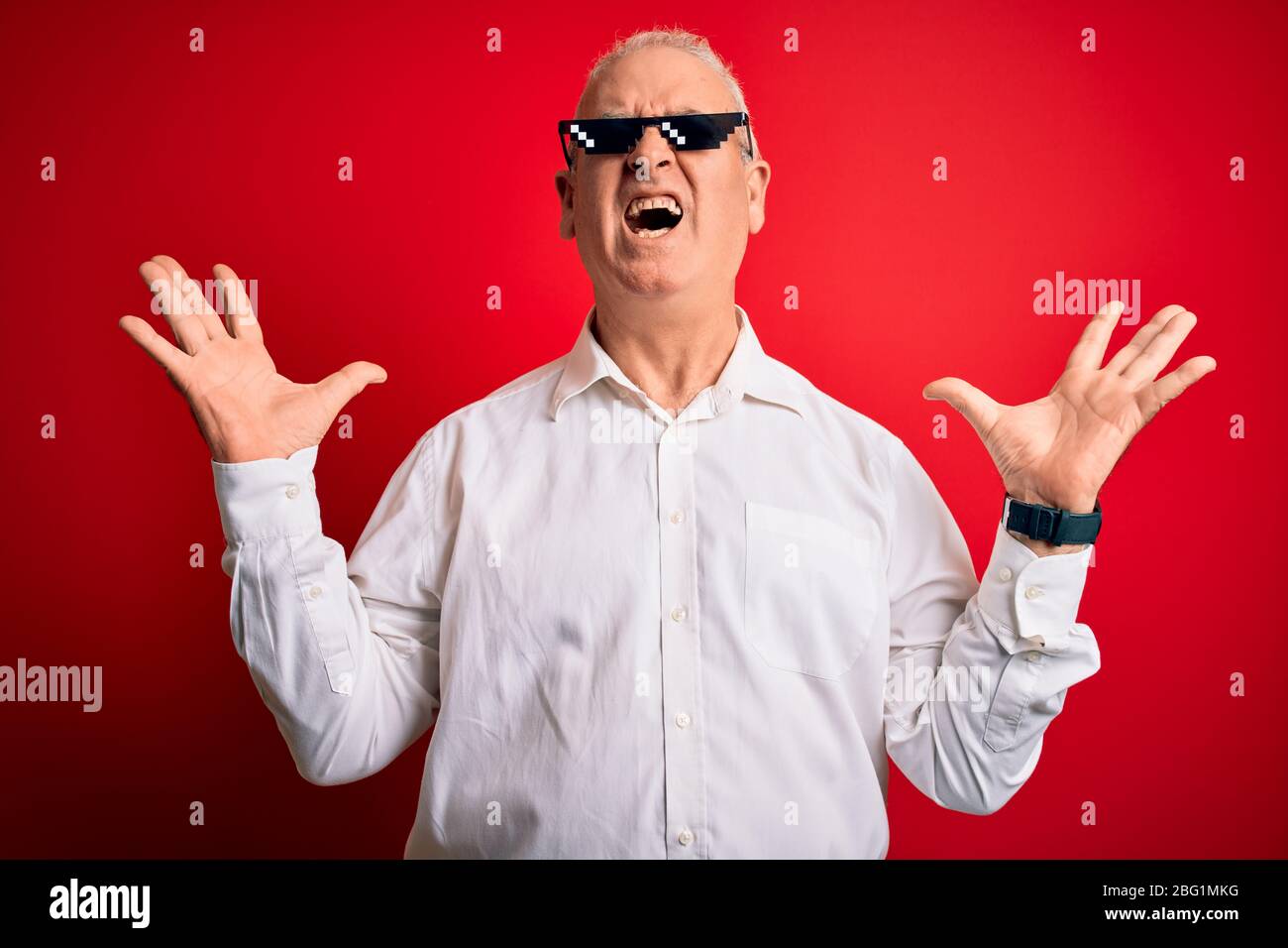 Middle age hoary man wearing funny sunglasses over isolated red ...