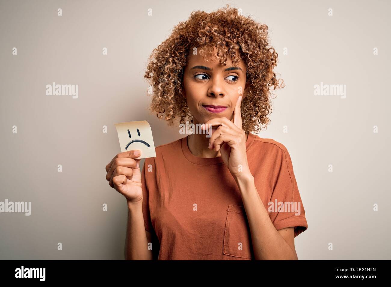 Young african american woman with curly hair holding reminder paper ...