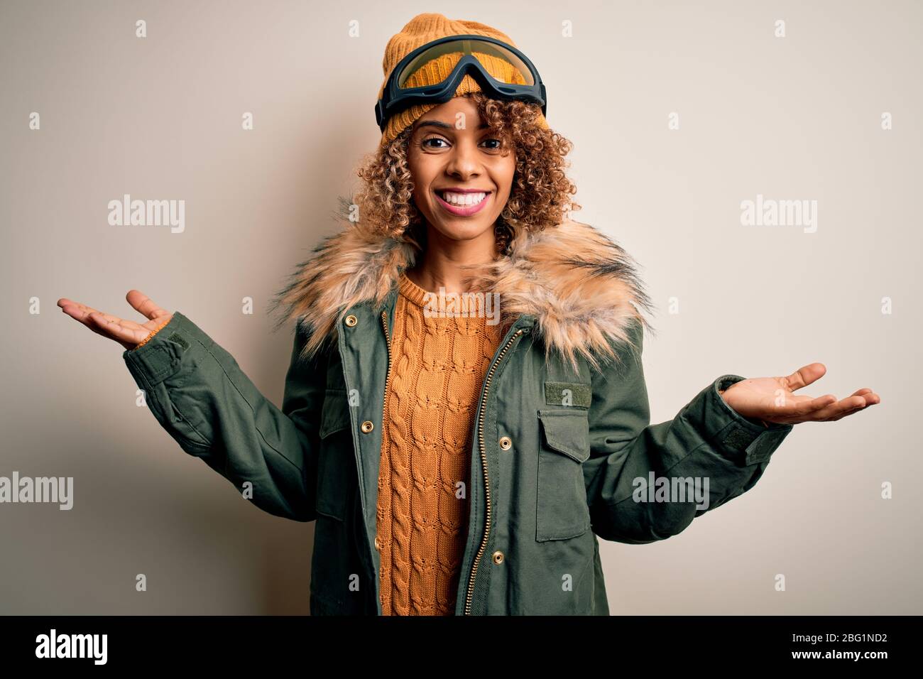 Young african american skier woman with curly hair wearing snow ...