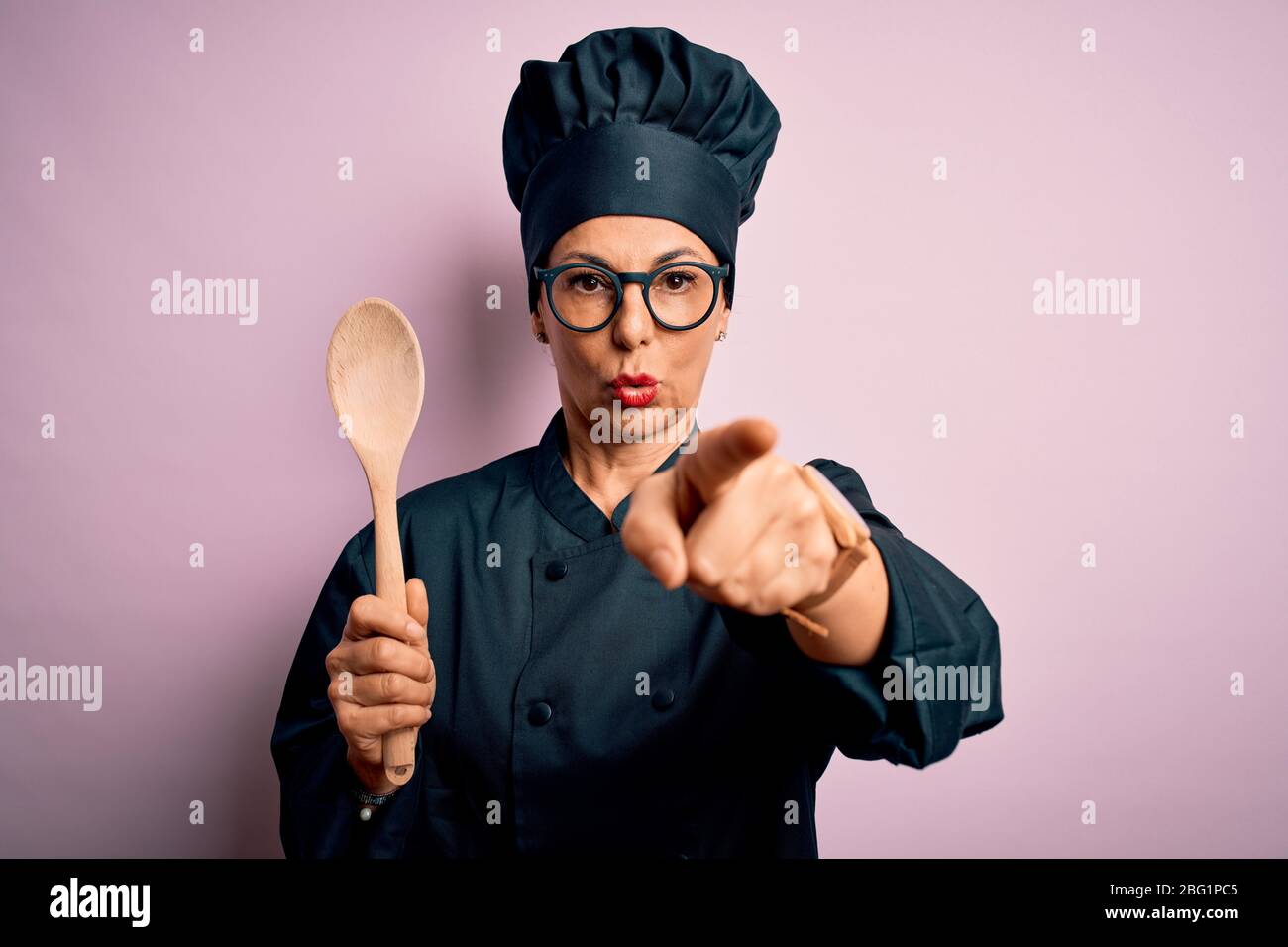 Middle age brunette chef woman wearing cooker uniform and hat holding ...