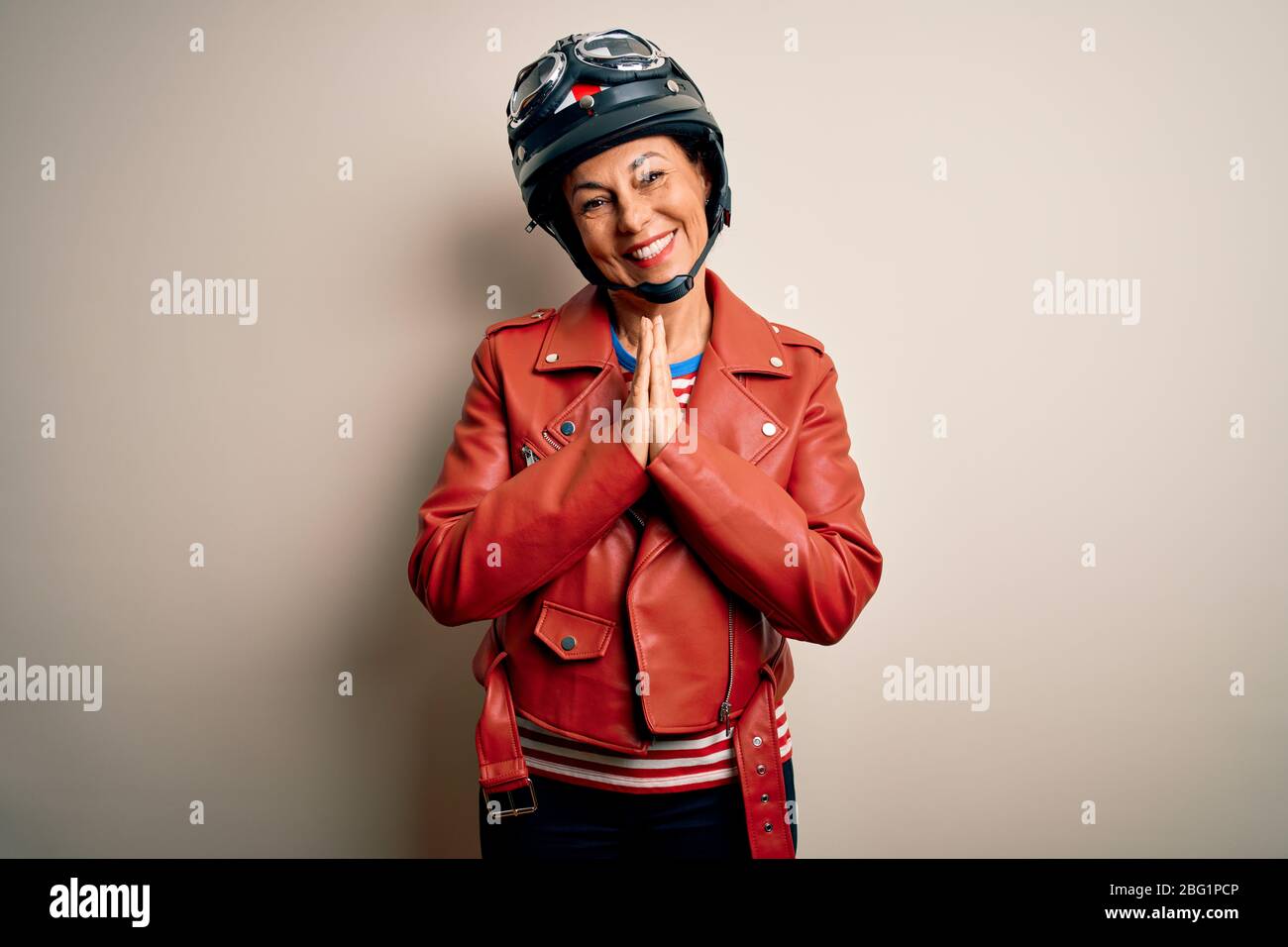Middle age motorcyclist woman wearing motorcycle helmet and jacket over ...