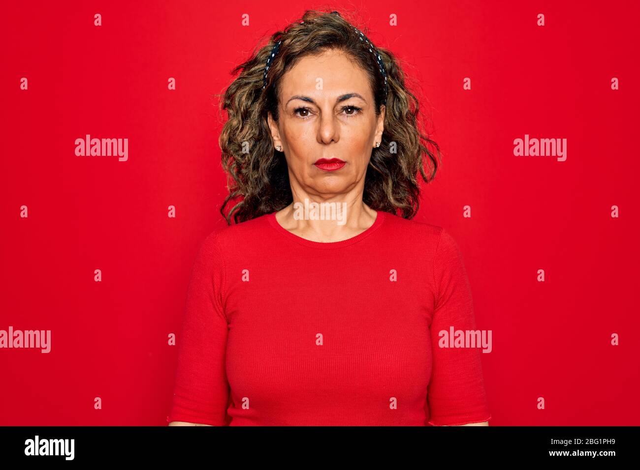 Middle age senior brunette woman wearing casual t-shirt standing over ...