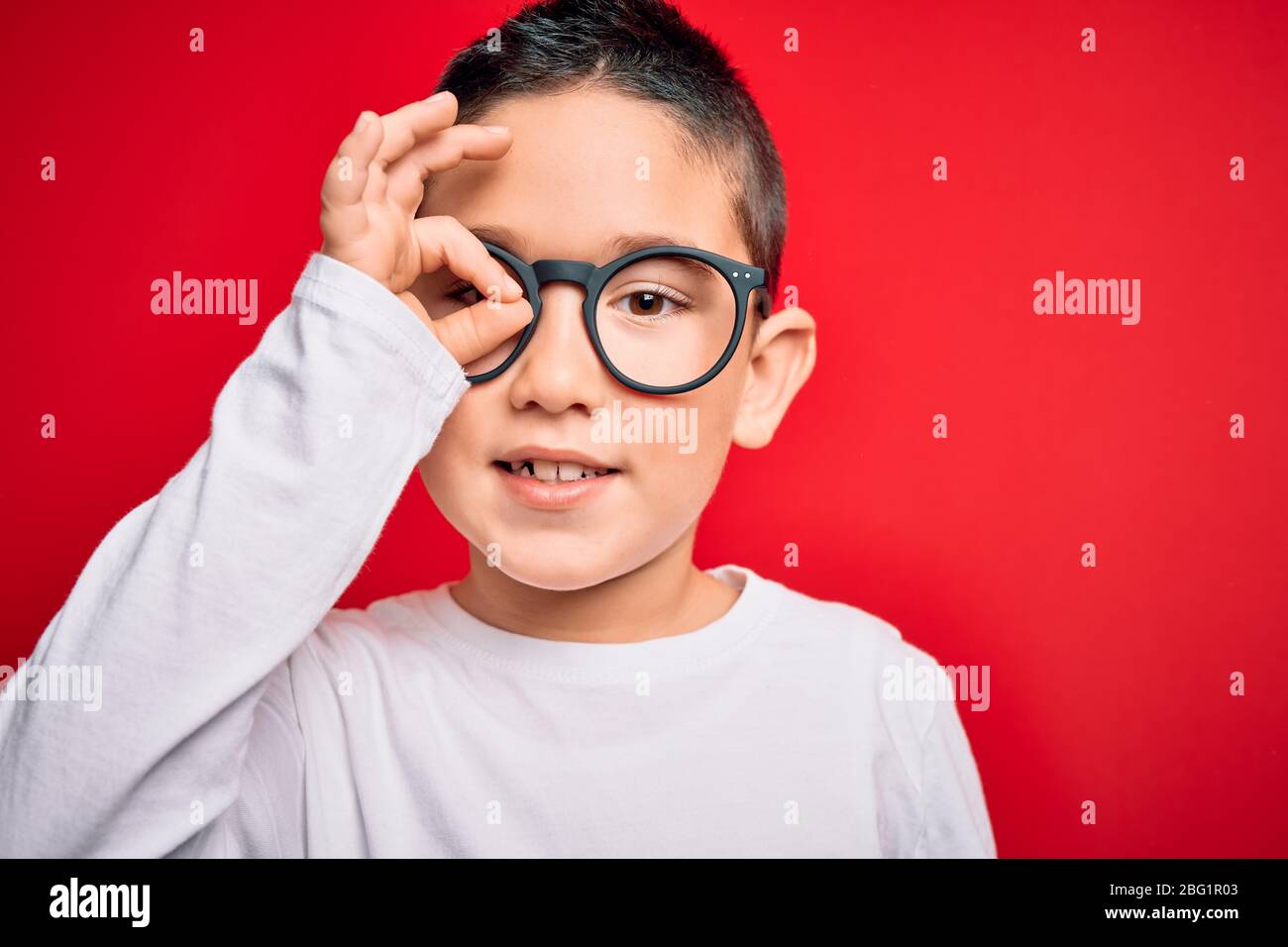 Young little smart boy kid wearing nerd glasses over red isolated ...