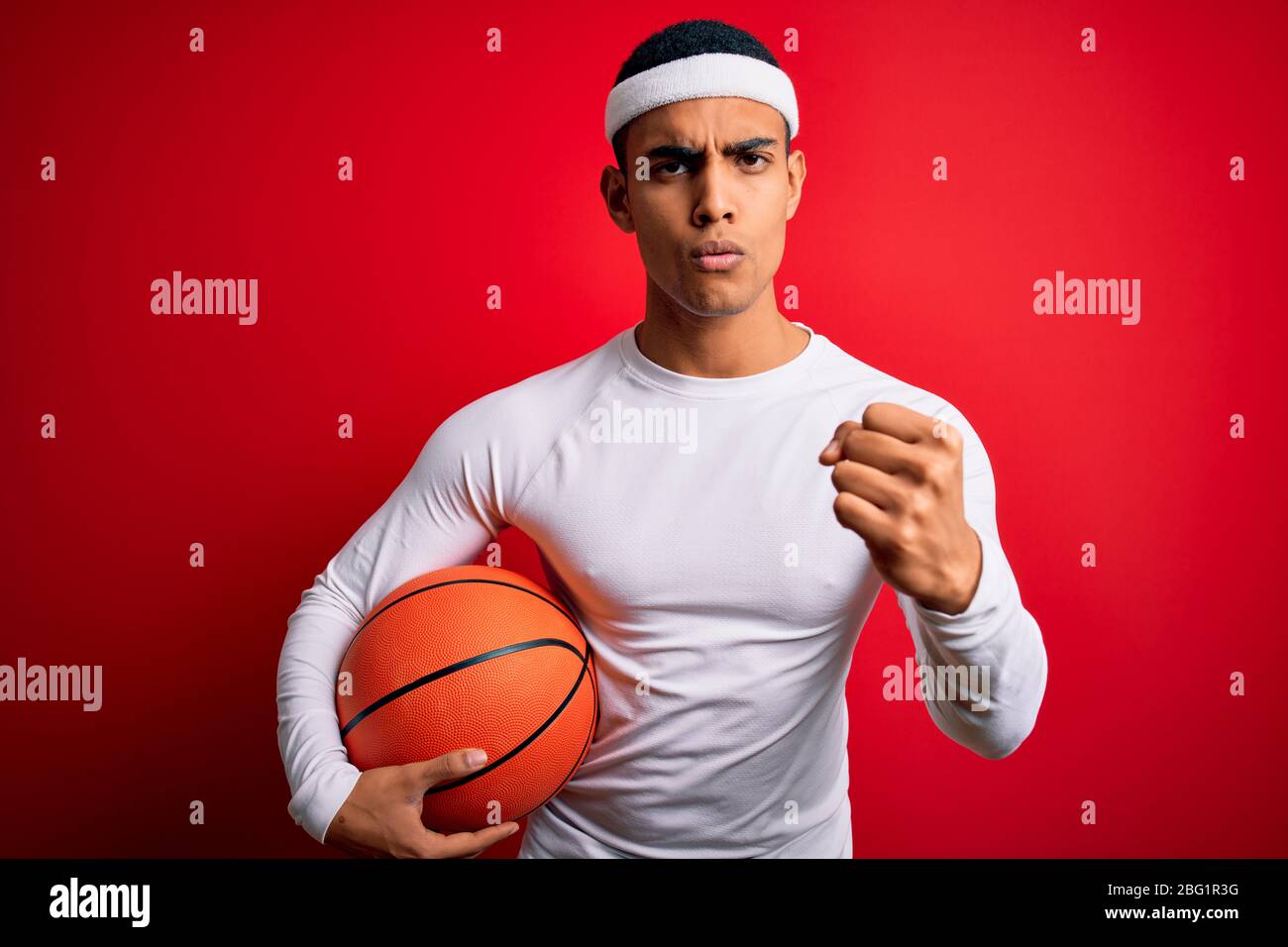 Young handsome african american sportsman holding basketball ball over ...