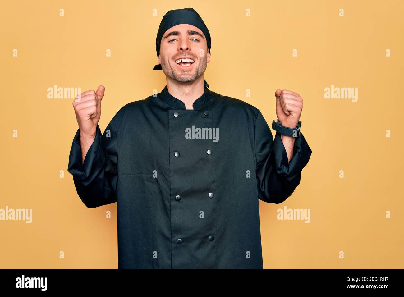 Young handsome cooker man with blue eyes wearing uniform and hat over ...
