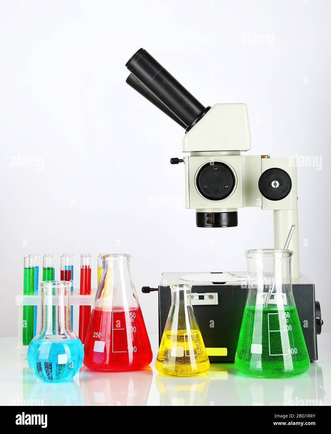Test tubes with colorful liquids and microscope isolated on white Stock ...