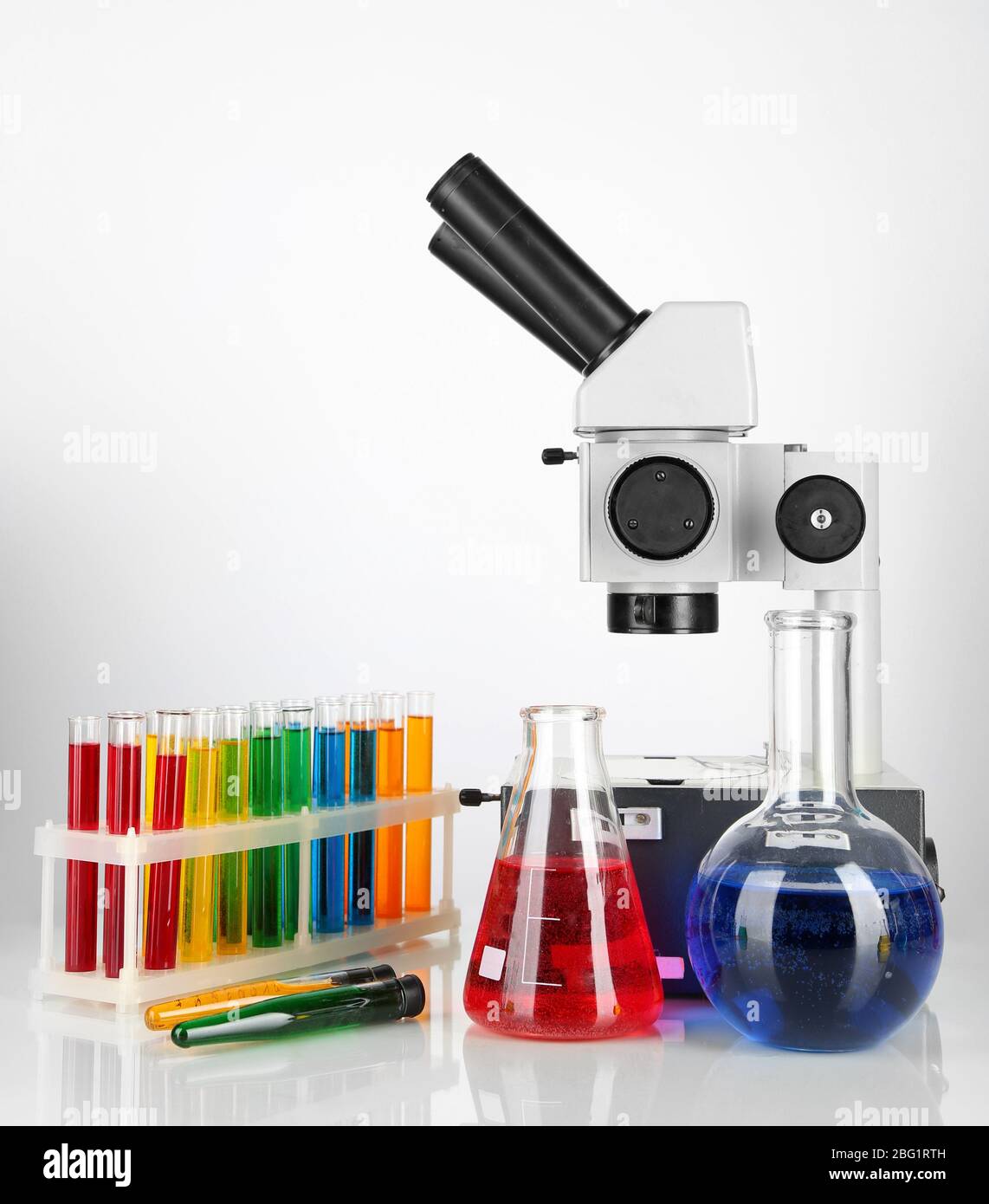Test tubes with colorful liquids and microscope isolated on white Stock ...