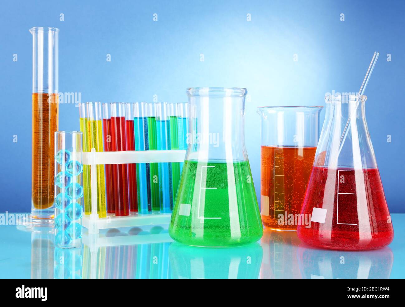 Test tubes with colorful liquids on blue background Stock Photo - Alamy