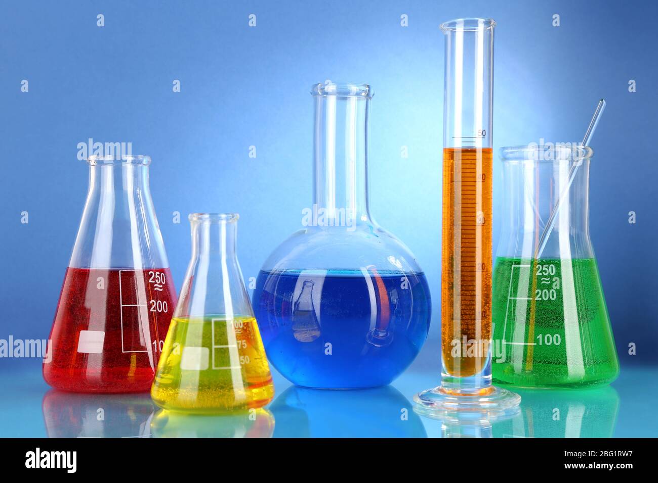 Test tubes with colorful liquids on blue background Stock Photo - Alamy