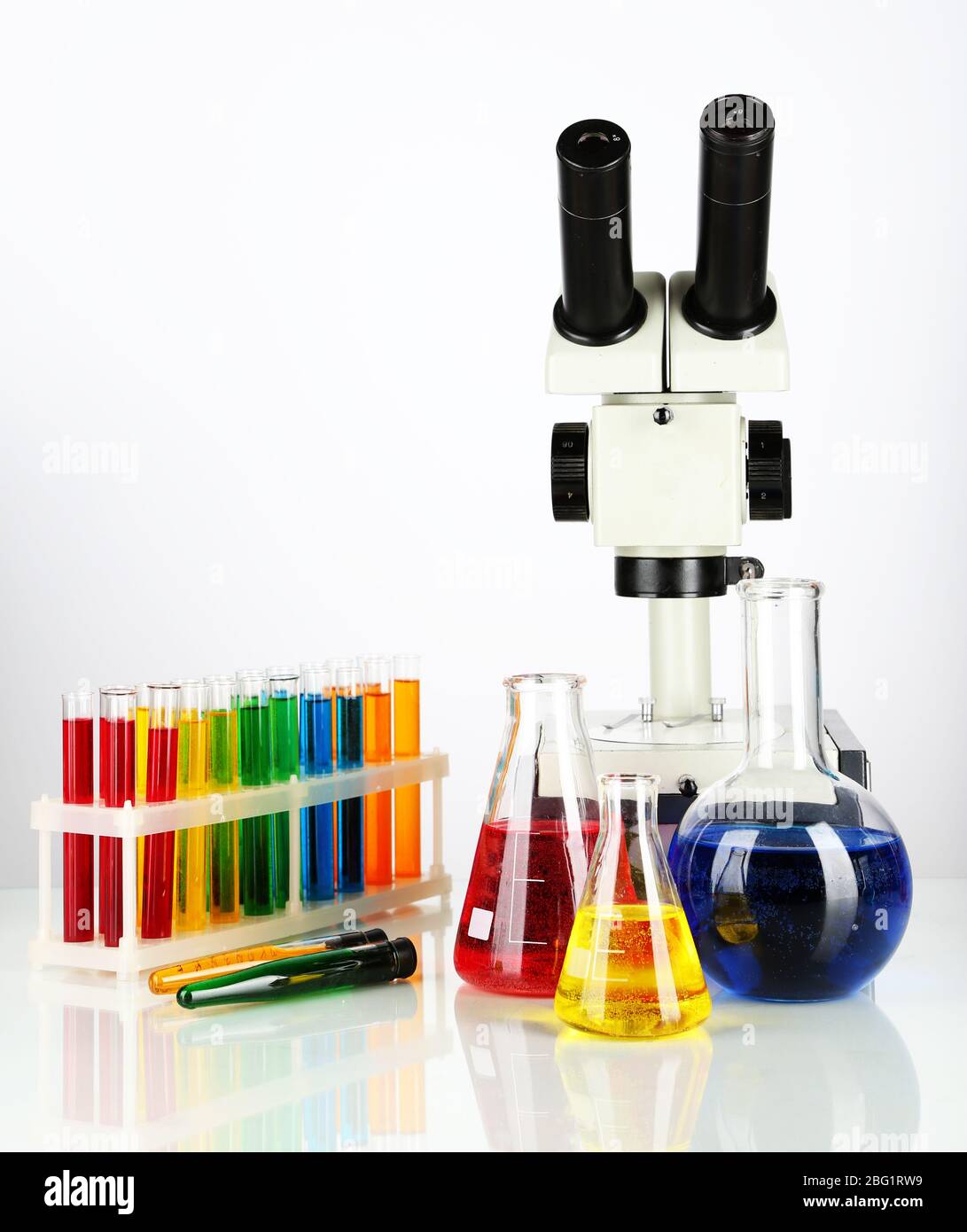 Test tubes with colorful liquids and microscope isolated on white Stock ...